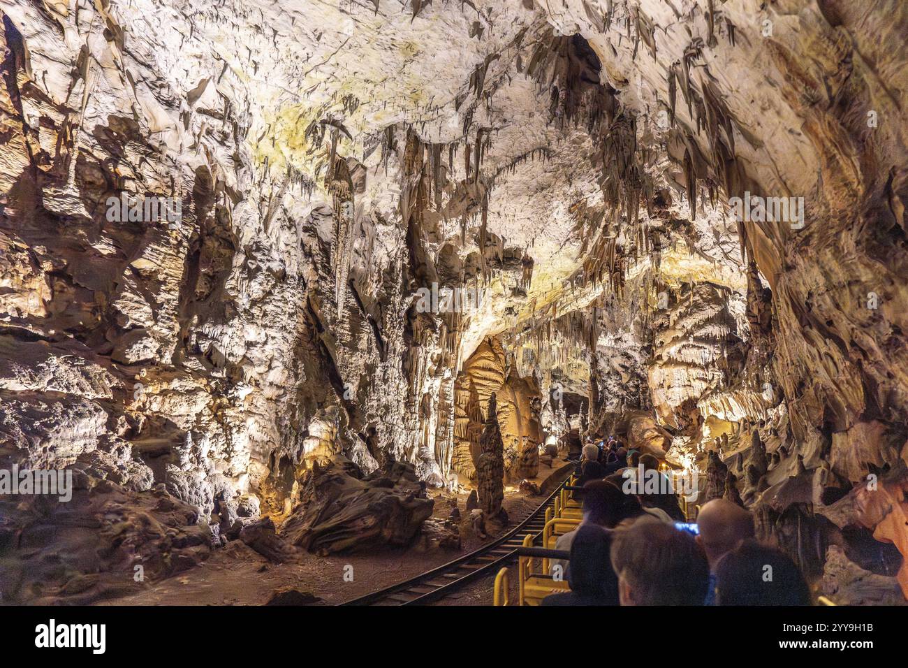 Tourists riding an electric train exploring the magnificent postojna ...