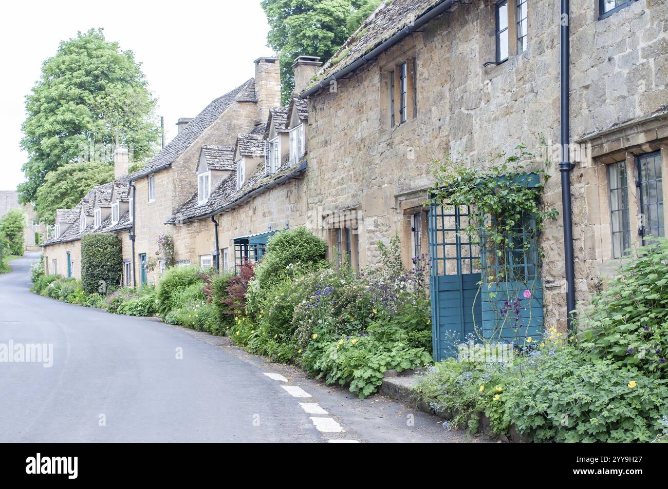 Charming stone cottages with colorful gardens create a peaceful scene ...