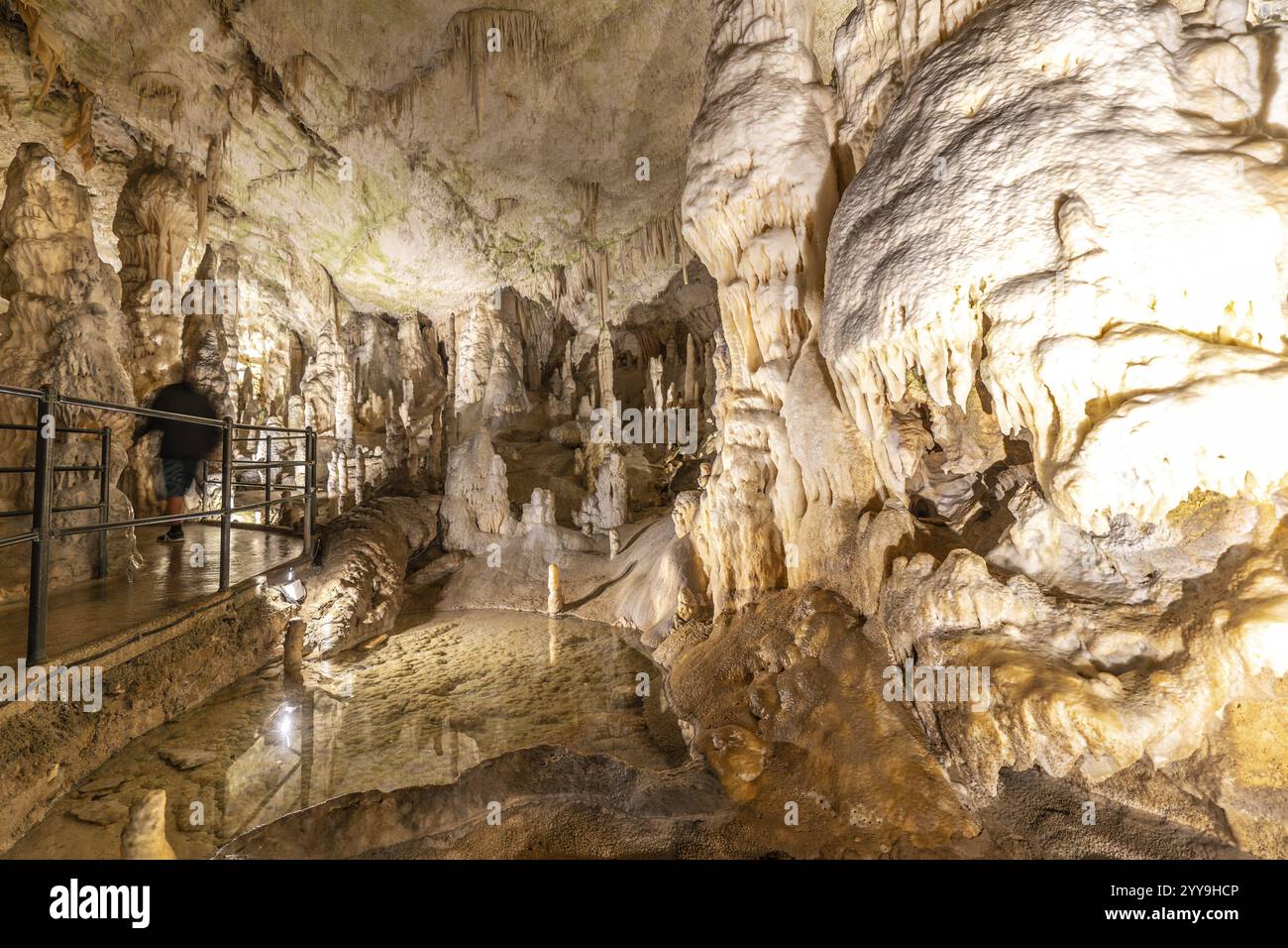 Tourists walking on a walkway marvel at the breathtaking stalactites ...