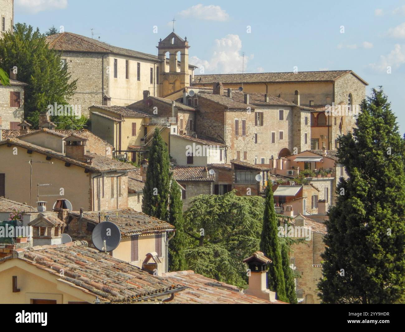 Clustered terracotta rooftops, a church tower, and lush greenery create ...