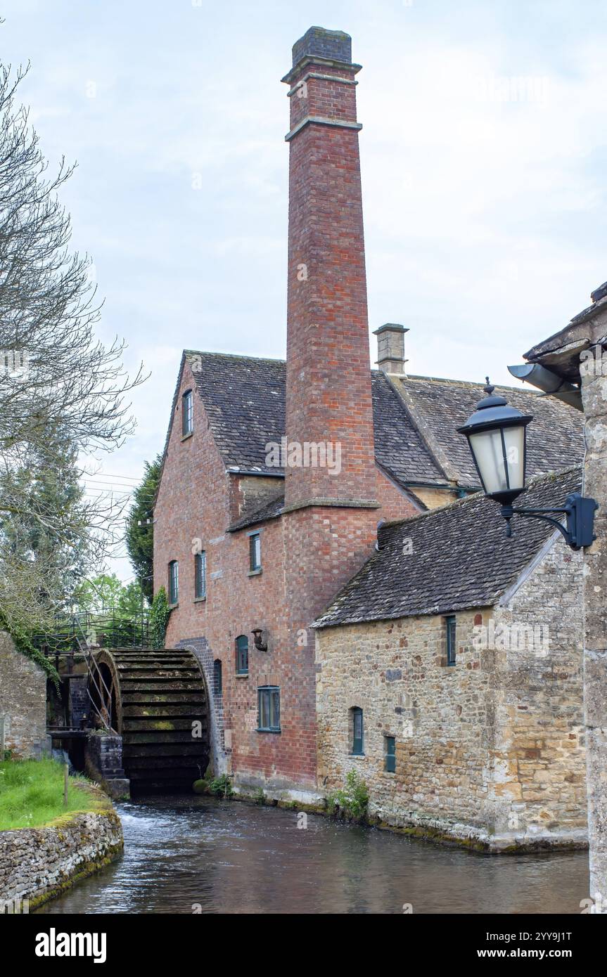 Scenic view of a historic watermill featuring a prominent brick chimney ...