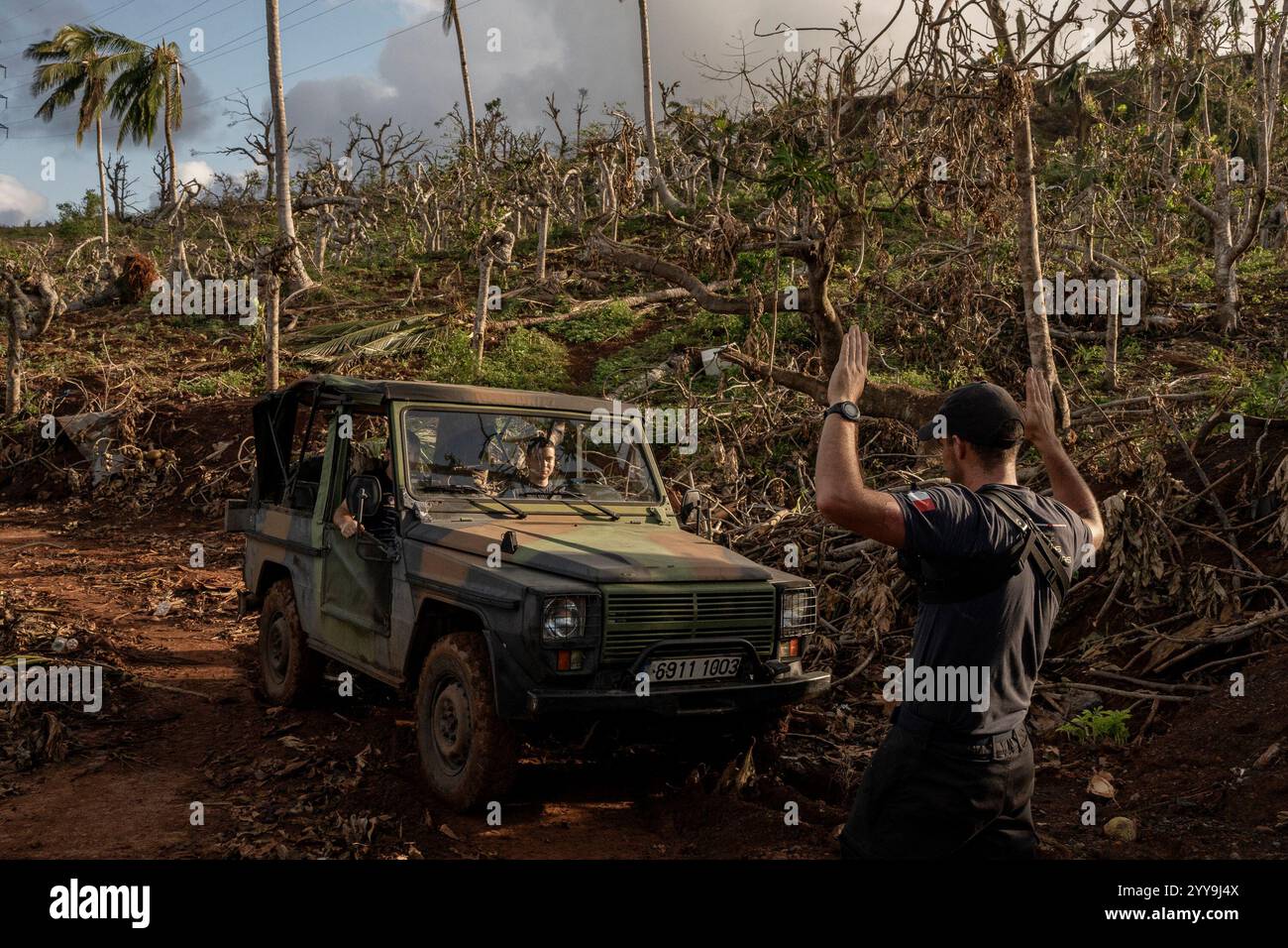 French civil security officers make their way through shredded trees ...