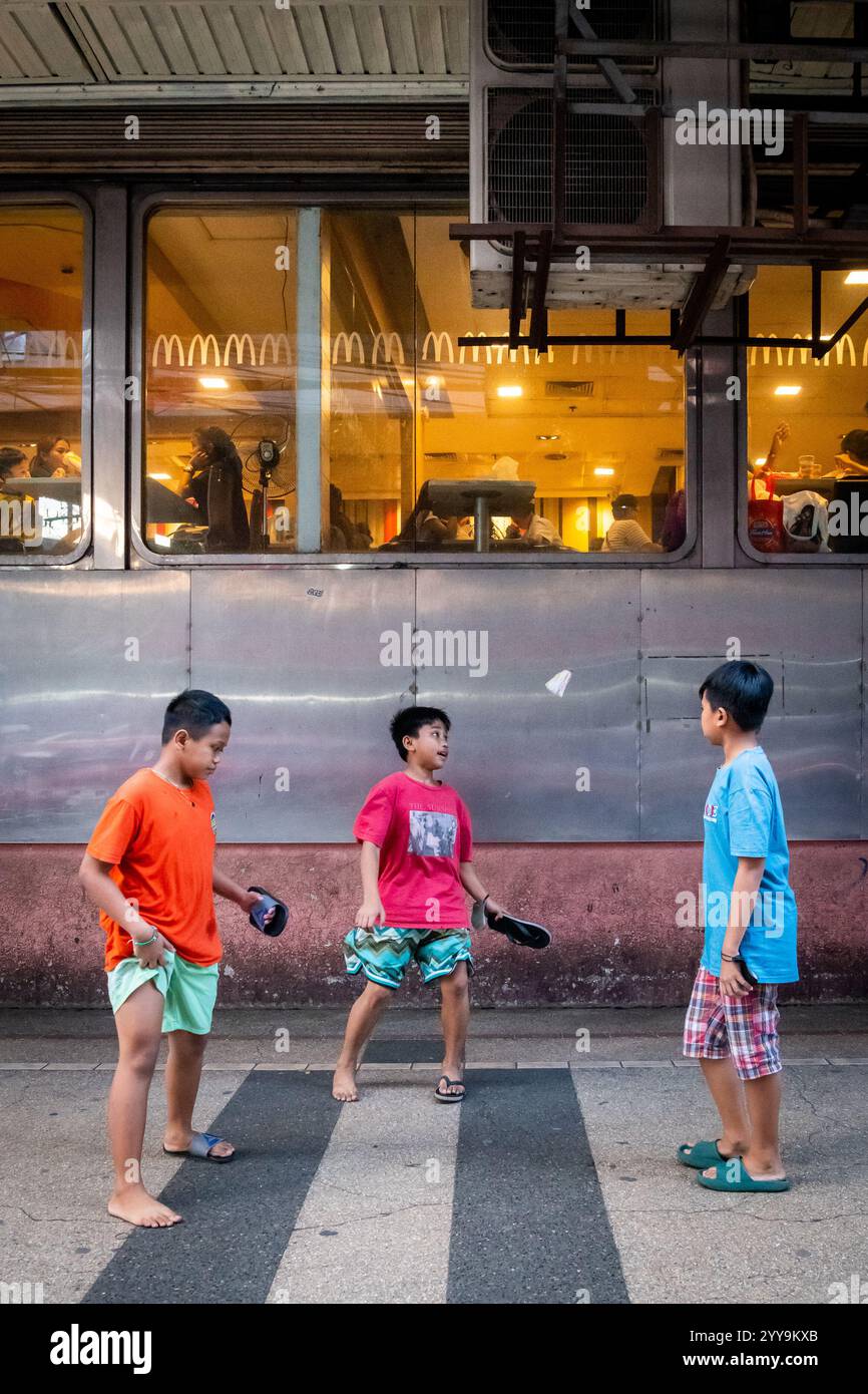 Filipino boys kick a shuttlecock between each other on the streets of ...
