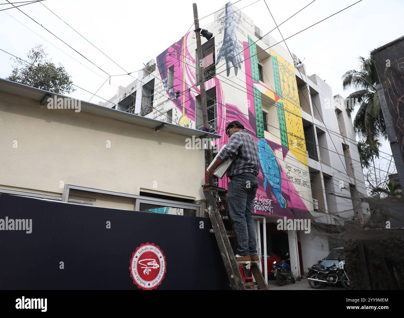 Kolkata, India. 20th Dec, 2024. An electrician installs a light on a ...