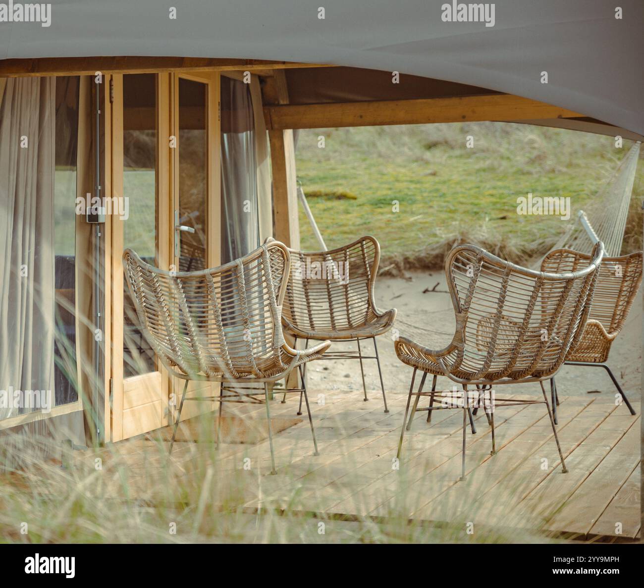 the outdoor leisure terrace with chairs and hammock in a glamping tent ...