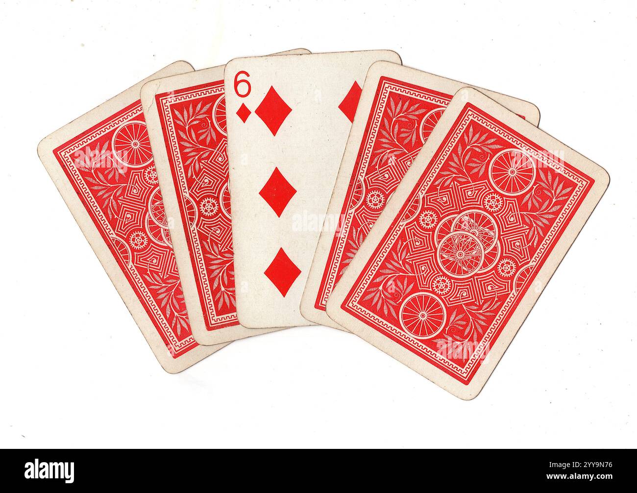 A hand of vintage playing card backs with the six of diamonds revealed ...