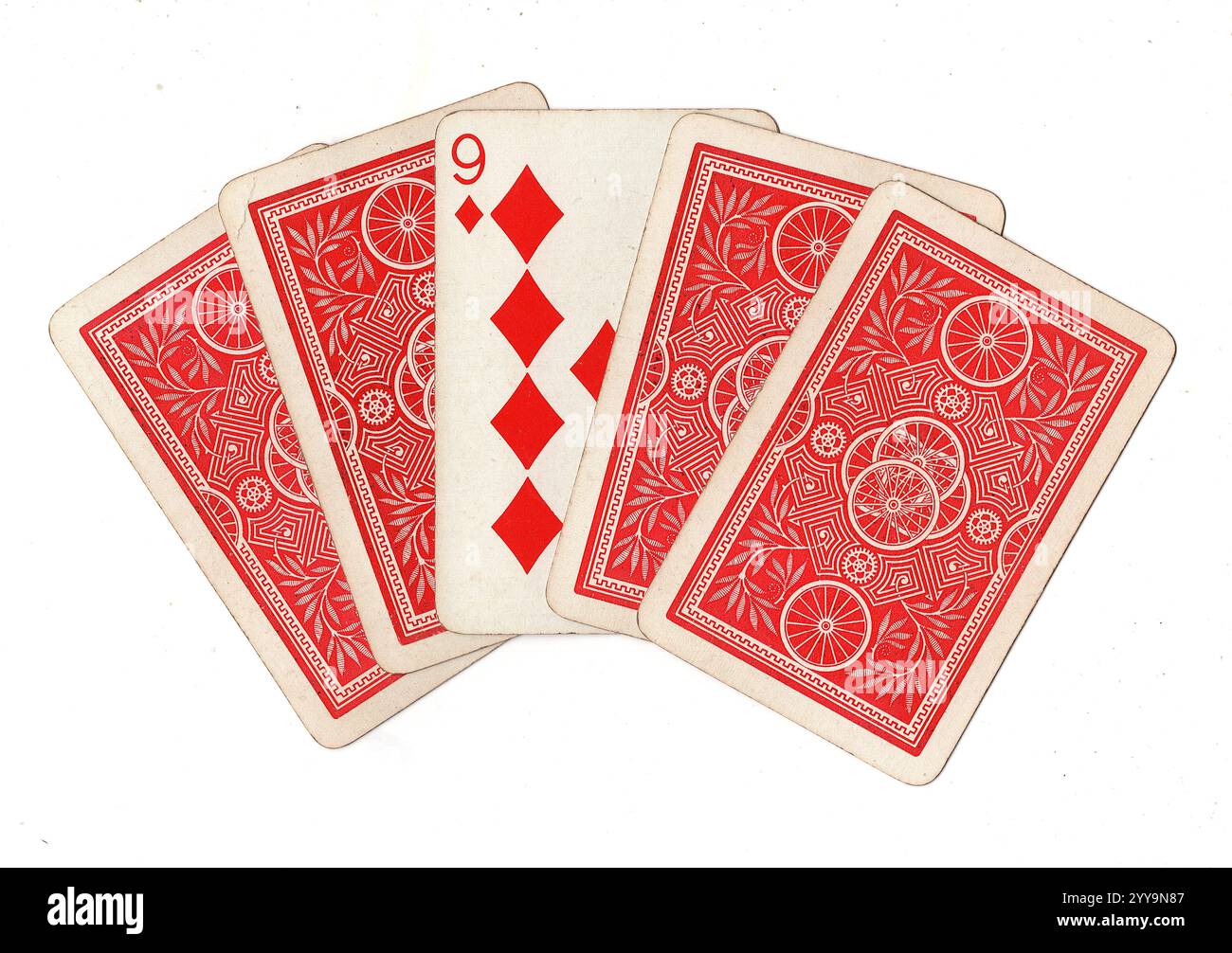 A hand of vintage playing card backs with the nine of diamonds revealed ...
