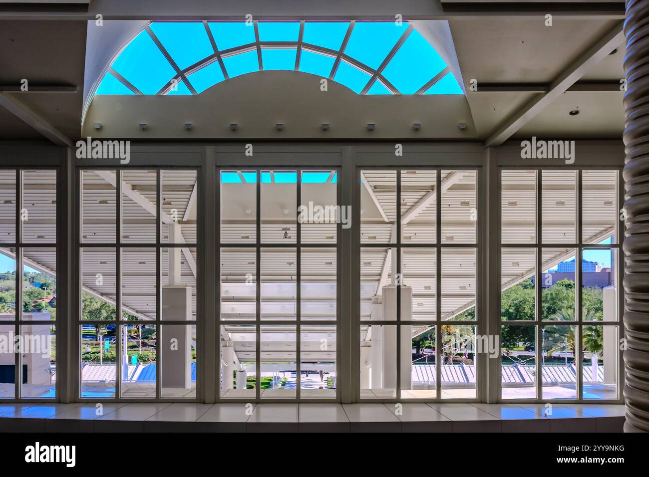 A large, open space with a white roof and a blue sky. The windows are ...