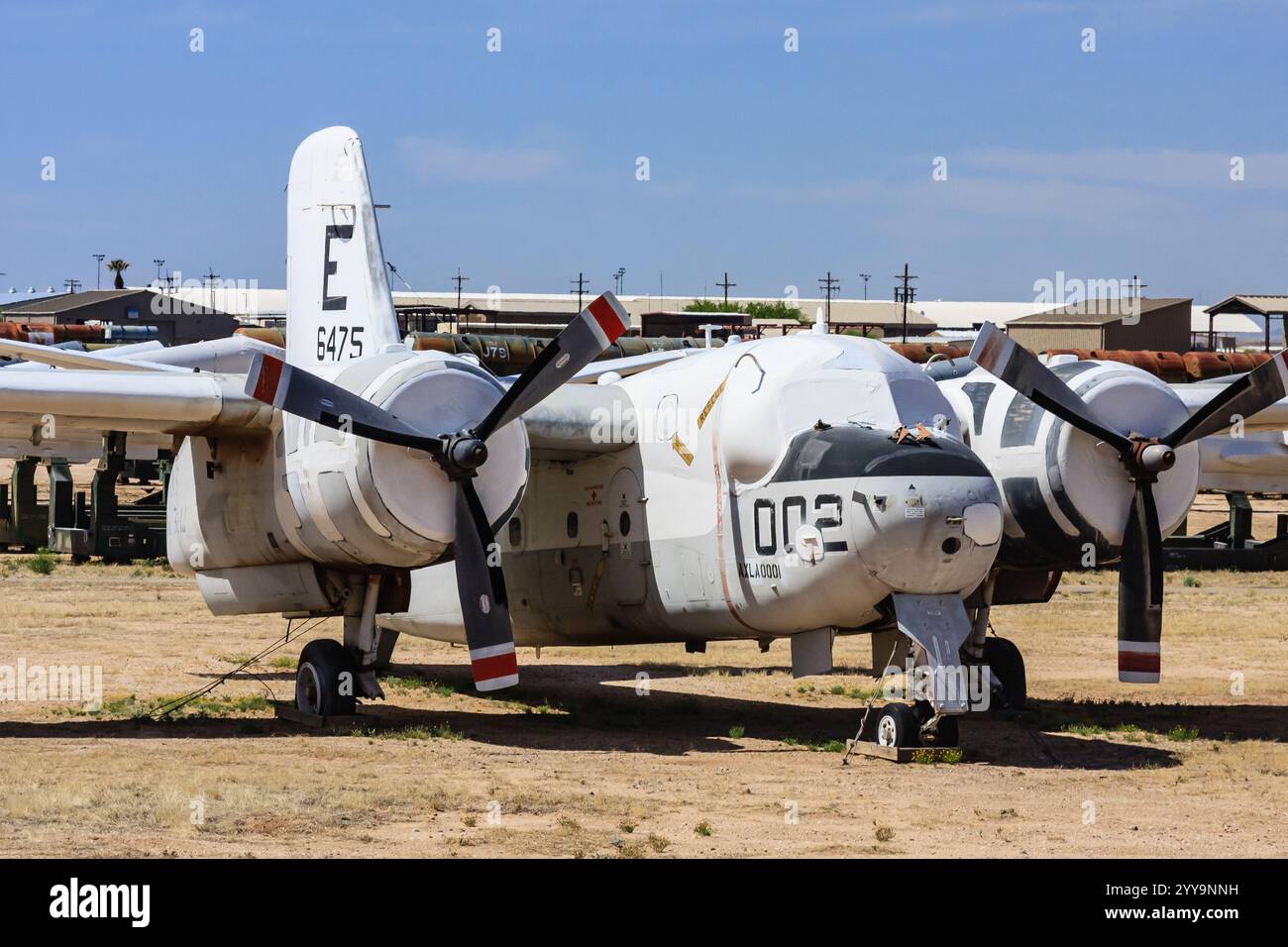 A large propeller plane is sitting on the ground in a desert. The plane ...