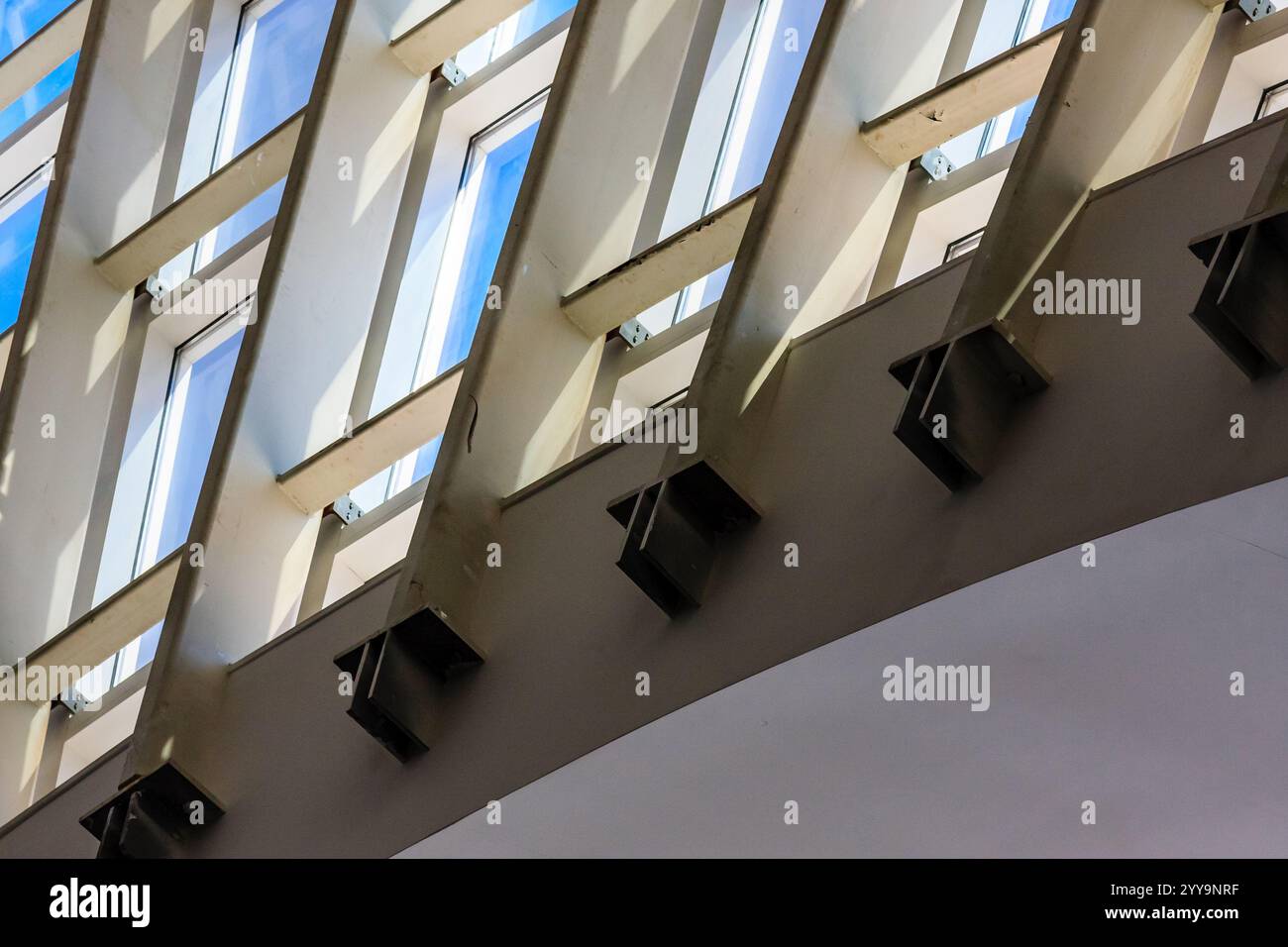 A building with a lot of windows and a lot of sunlight coming in. The sunlight is shining ...