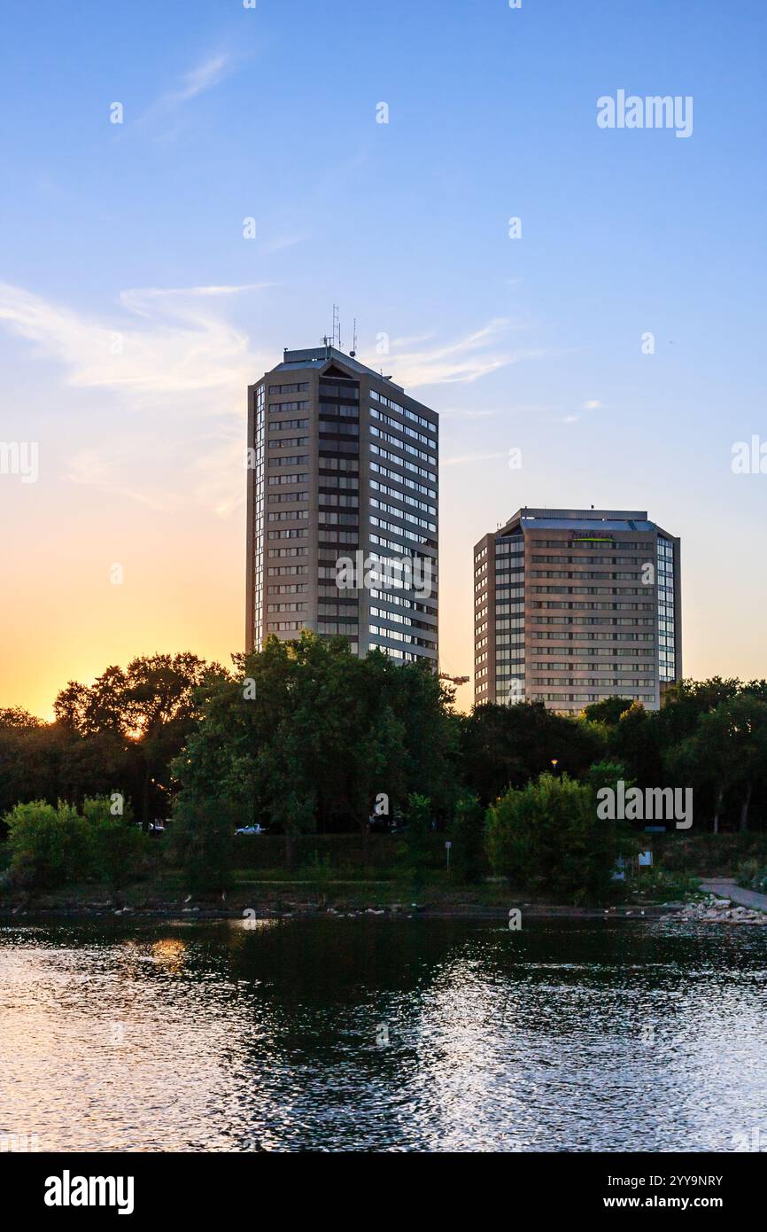 A beautiful sunset over a city skyline with two tall buildings in the ...