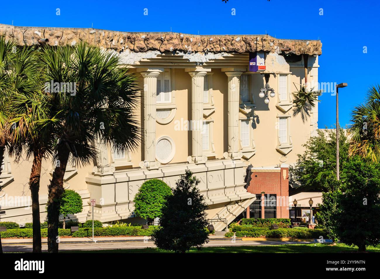 A building with a large white pillar on top of it. The building is in a ...