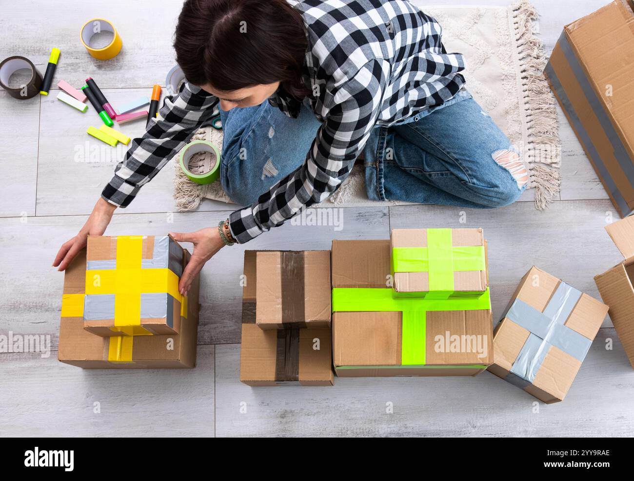 Girl Packs Cardboard Boxes And Seals Them With Tape At Home As She ...