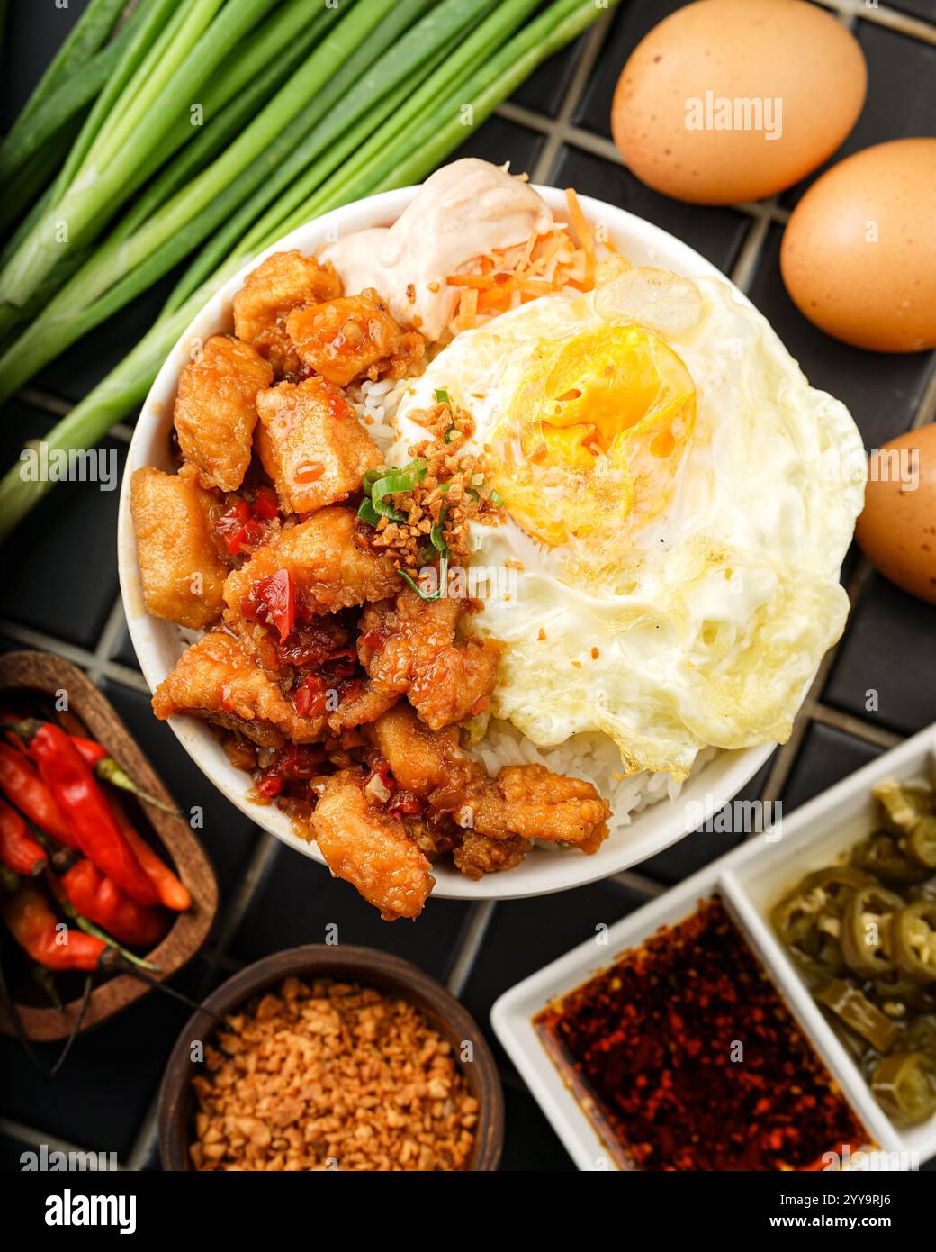 Crispy fried chicken rice bowl topped with a sunny-side-up egg, fresh ...