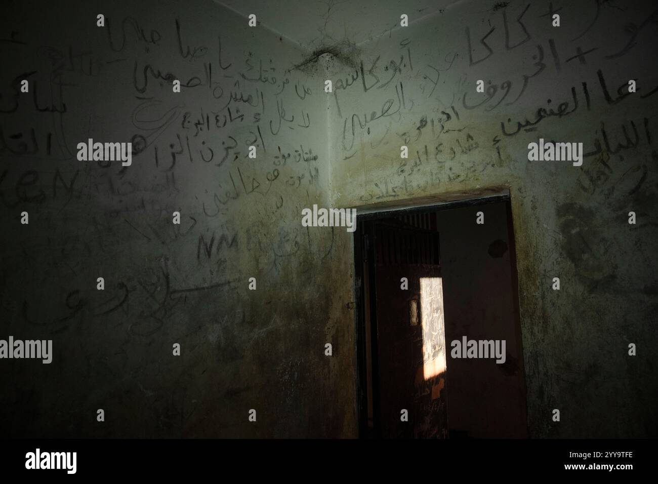 Names of people and places in Arabic are written on walls inside a cell ...