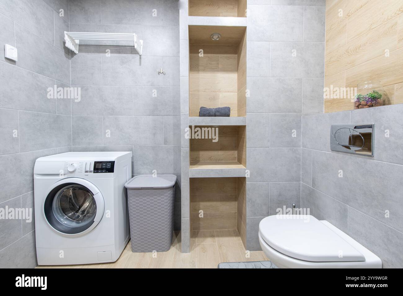 Clean and stylish bathroom featuring a washing machine, toilet, and ...