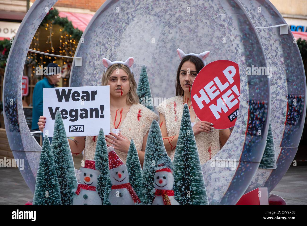 Two activists dressed as sheep while holding placards stand in a snow ...