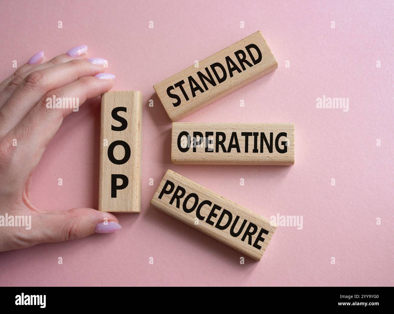 SOP - Standard Operating Procedure symbol. Wooden blocks with word SOP. Businessman hand ...