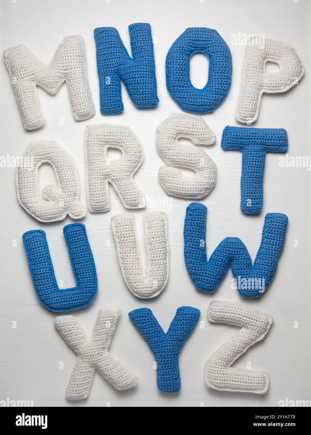 Handmade crocheted alphabet letters, blue and white, arranged on a ...