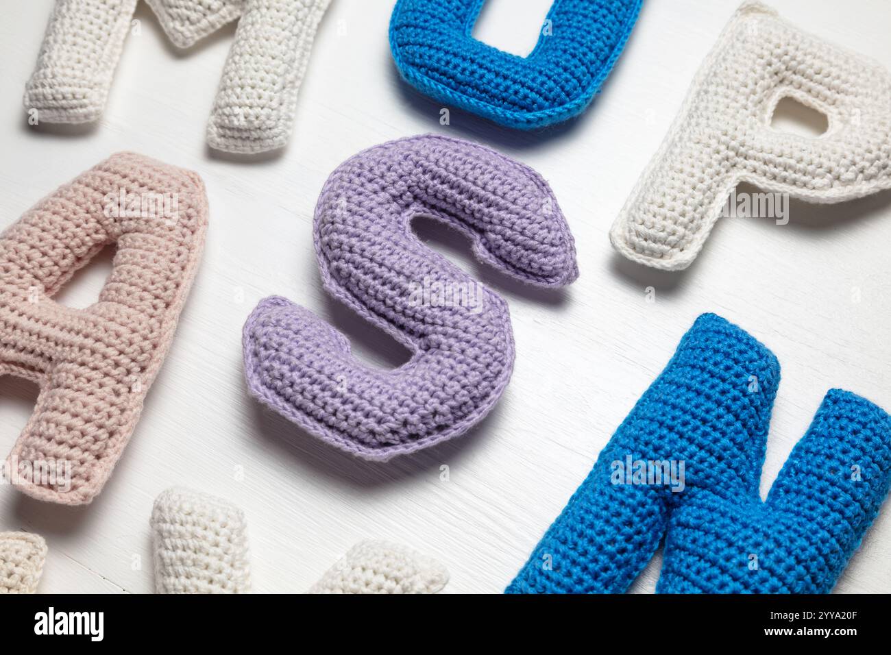 Handmade crocheted alphabet letters on a white background, showcasing ...