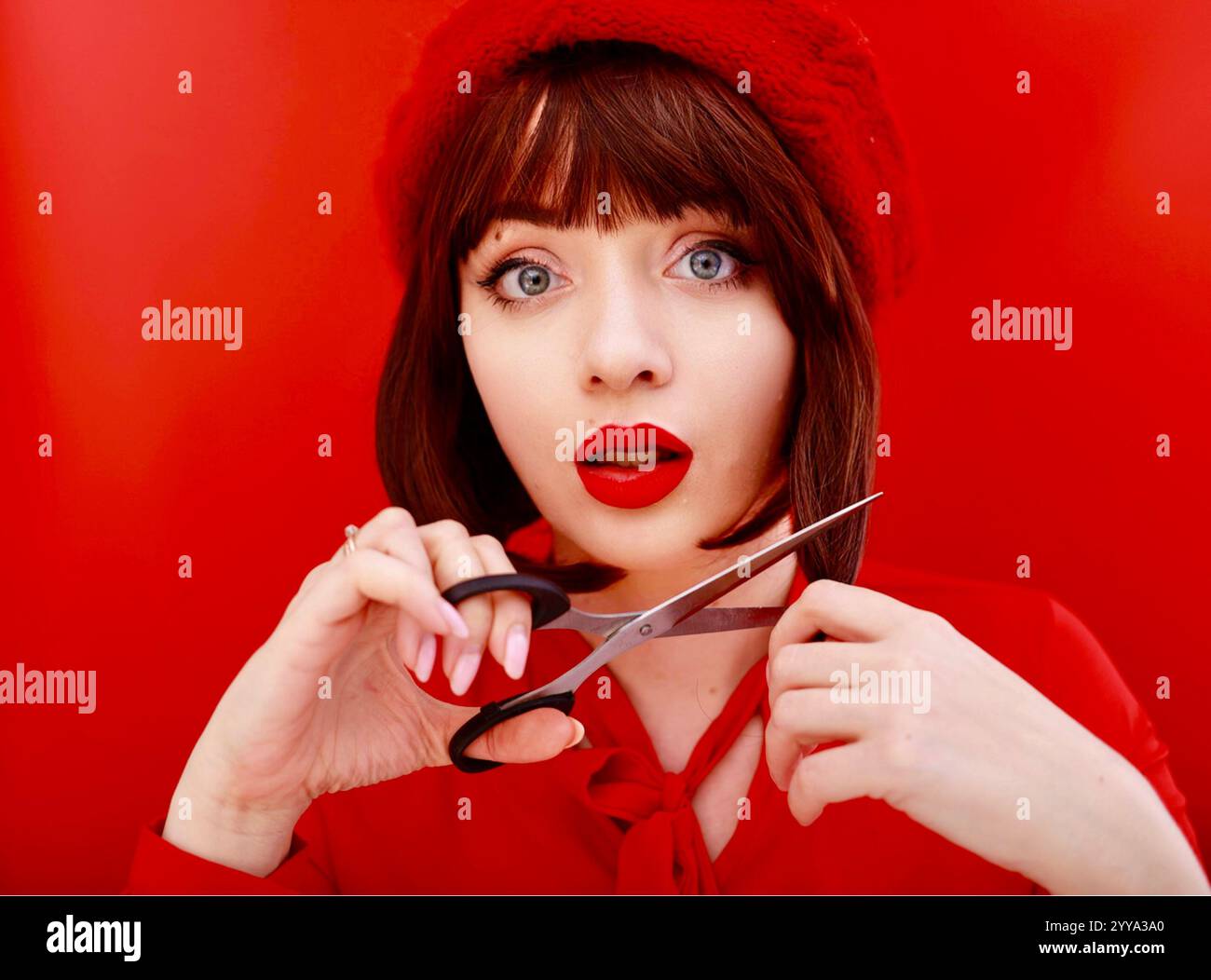 Haircut. Portrait of young woman hairdresser cutting hair with scissors ...