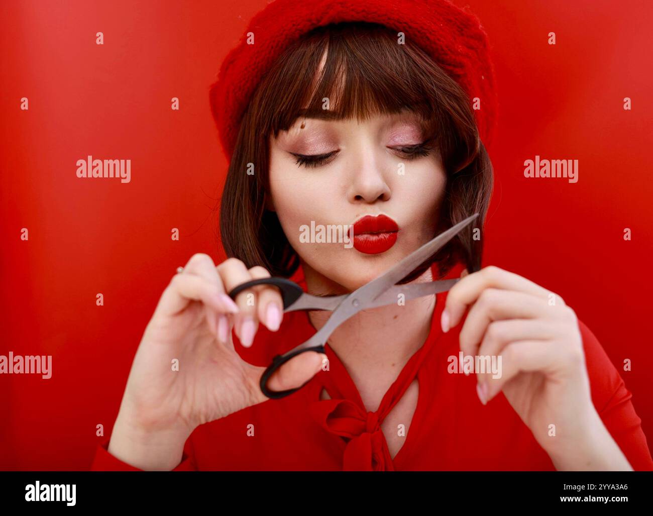 Haircut. Portrait of young woman hairdresser cutting hair with scissors ...