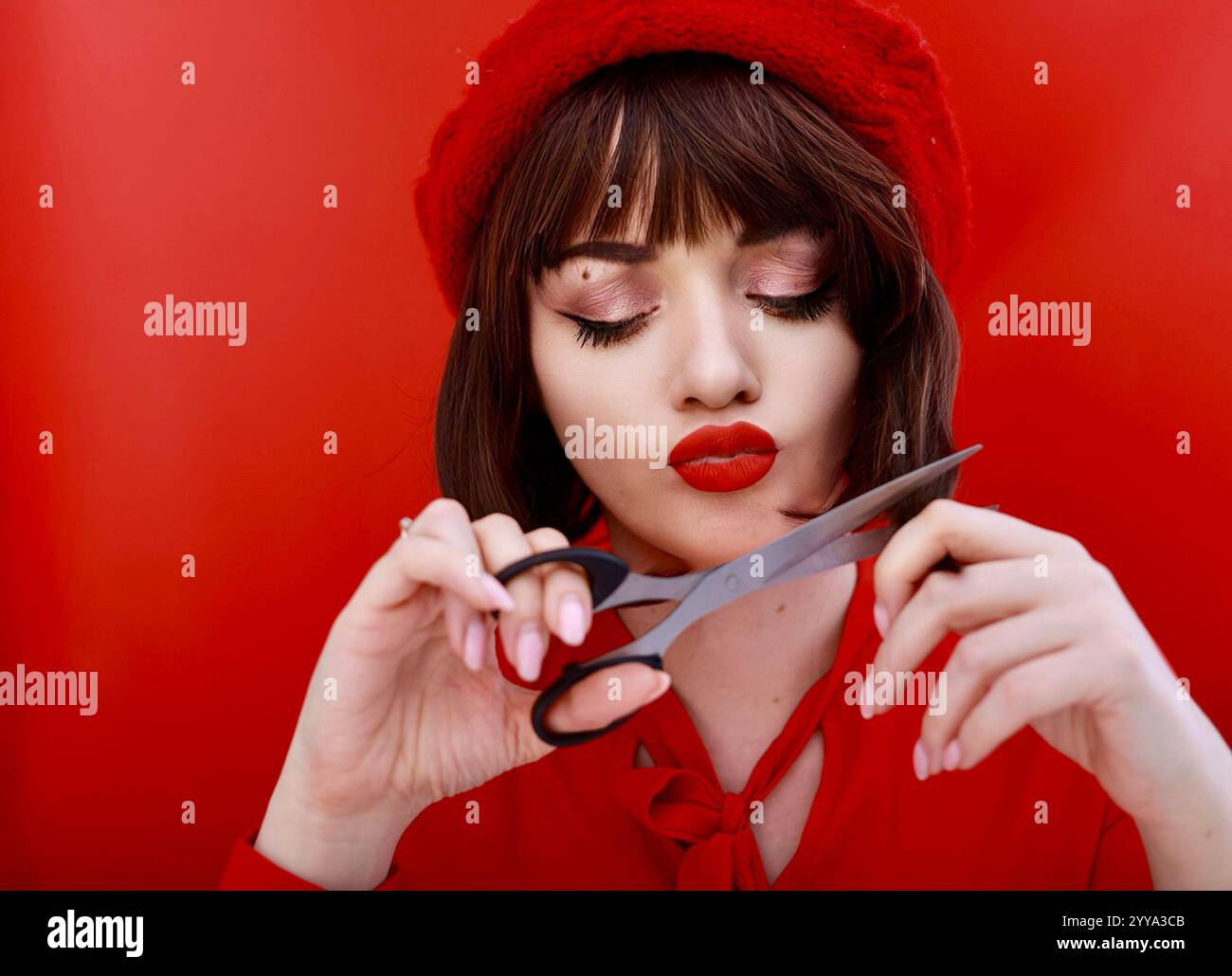 Haircut. Portrait of young woman hairdresser cutting hair with scissors ...