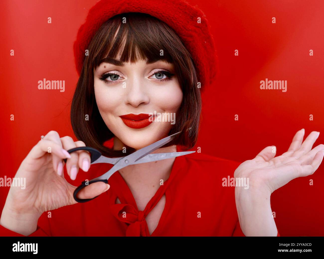 Haircut. Portrait of young woman hairdresser cutting hair with scissors ...