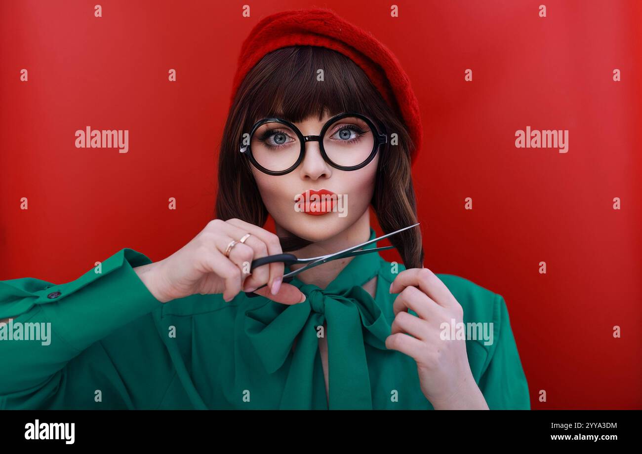 Haircut. Portrait of young woman hairdresser cutting hair with scissors ...