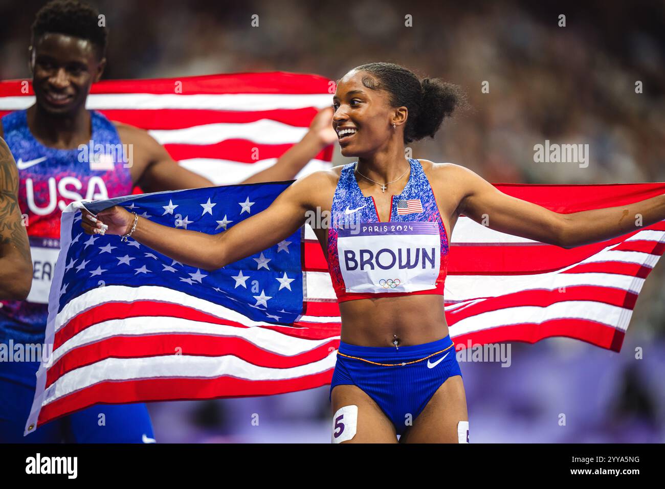Kaylyn Brown celebrating with her country's flag in the 4x400 meters ...