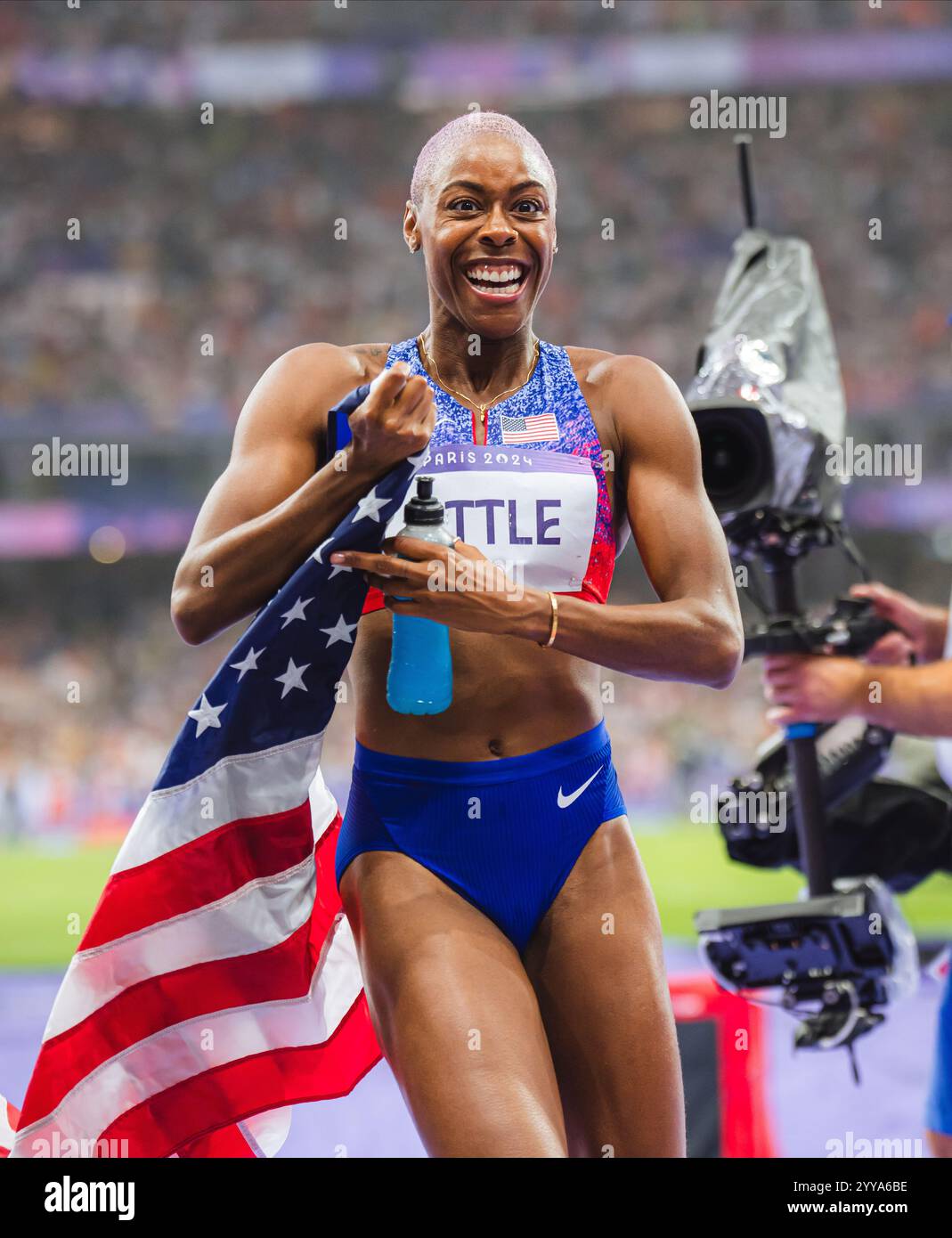Shamier Little celebrating with her country's flag in the 4x400 meters ...