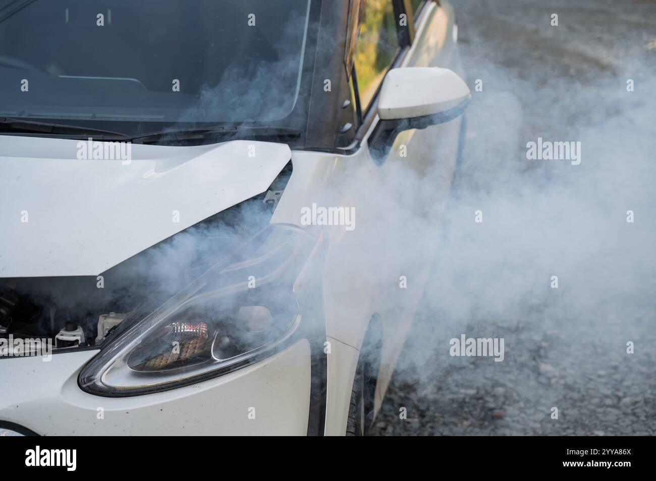 Smoke is coming from under the hood of the car Stock Photo - Alamy