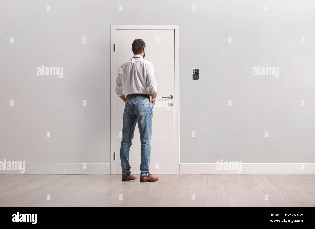 Man waiting in front of an apartment door Stock Photo - Alamy
