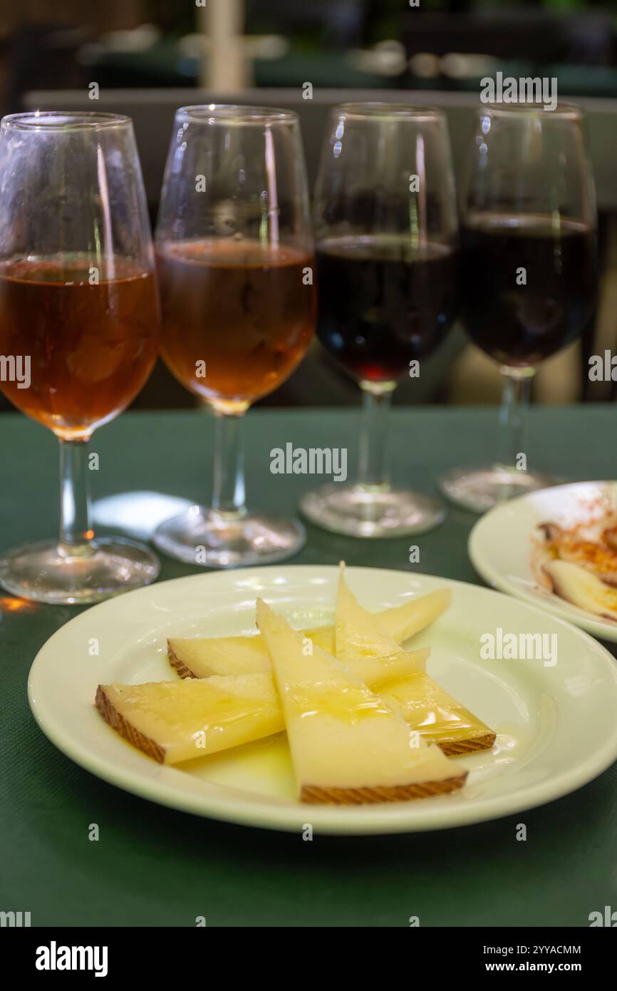 Tasting of Spanish sherry wine and cheeses, triangles of manchego ...