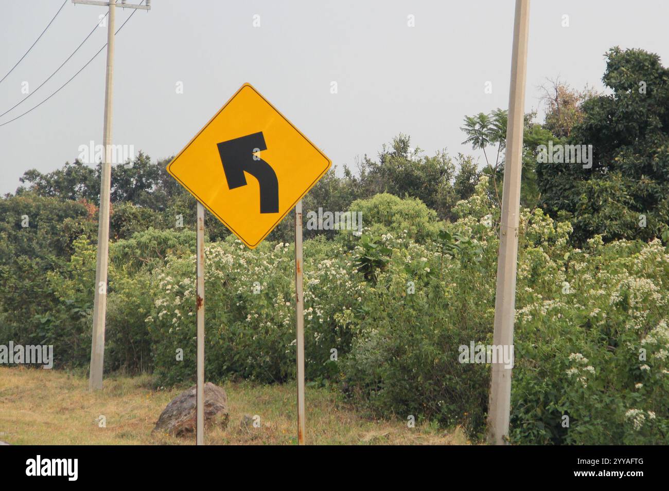 Arrow sign to the left of a curve on the road indicates the movement ...