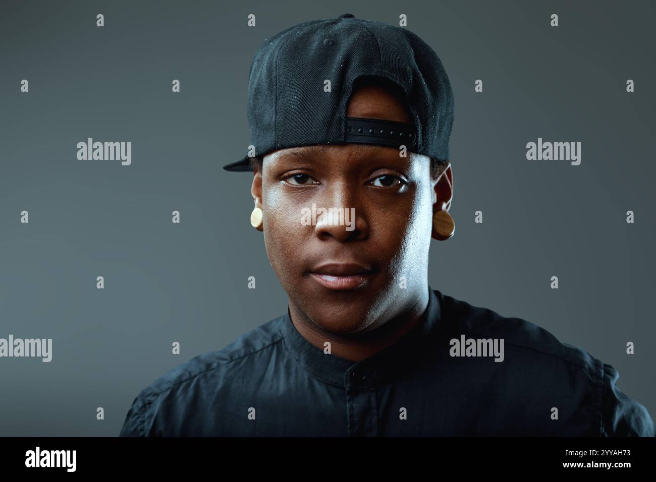 Portrait featuring a serious young african-american man with ear plugs ...