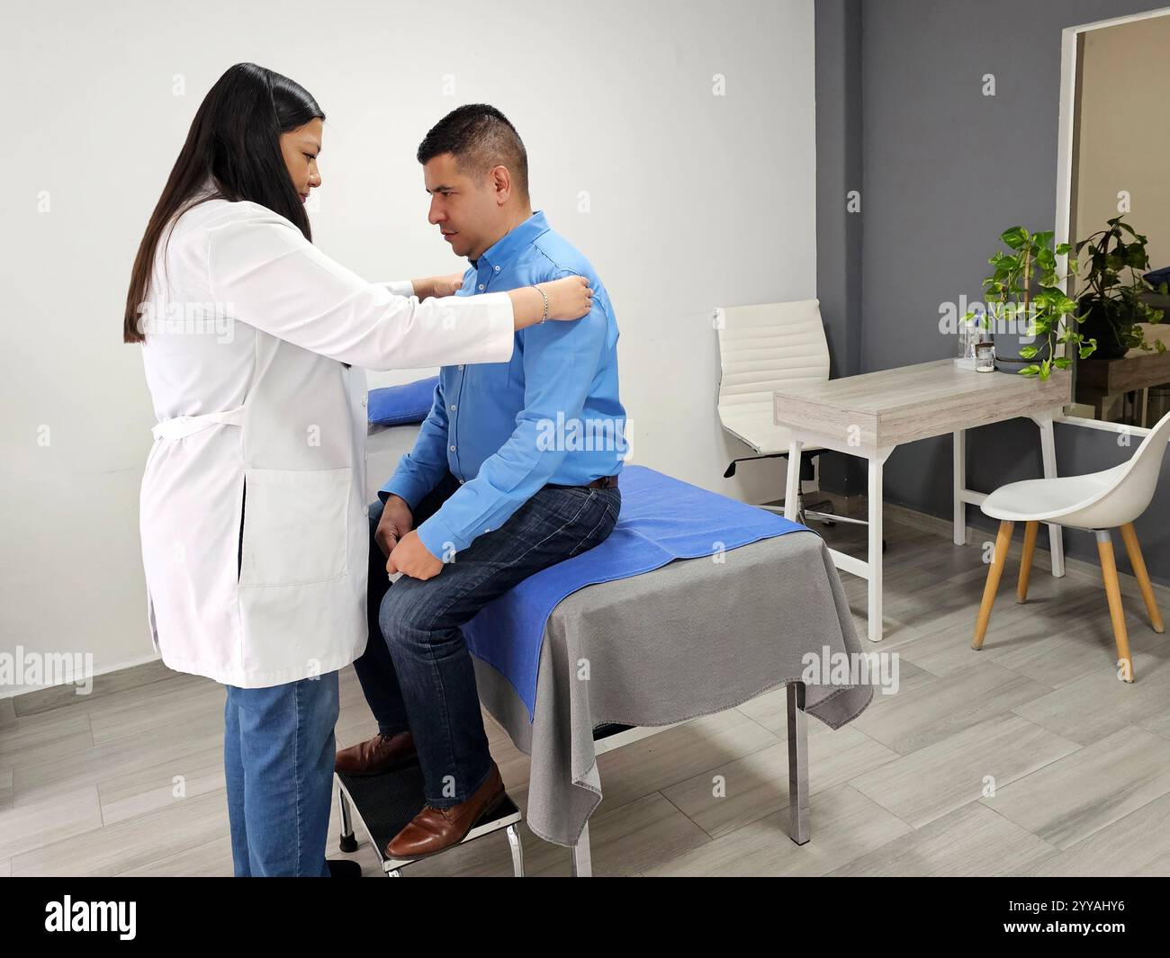 Latina specialist doctor woman checks her dark-skinned male patient ...