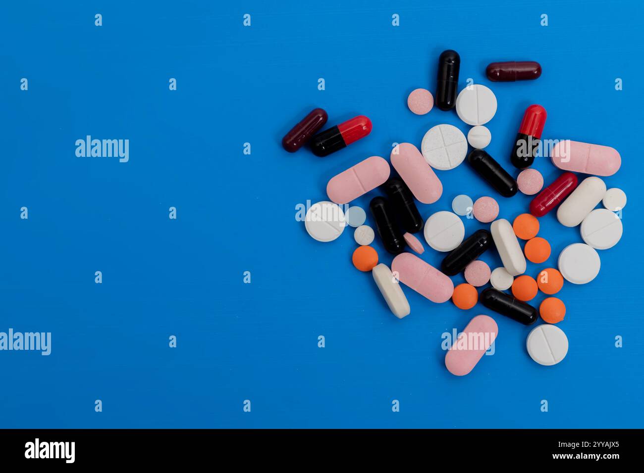 A collection of colorful pills and capsules scattered over a vibrant ...