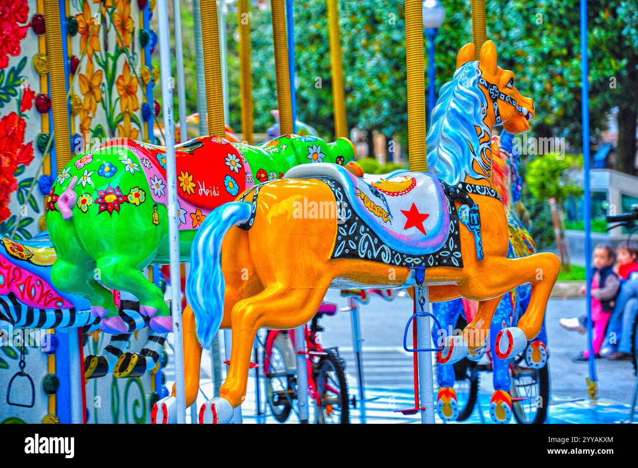 A big attraction for children: Green and yellow carousel horses in ...