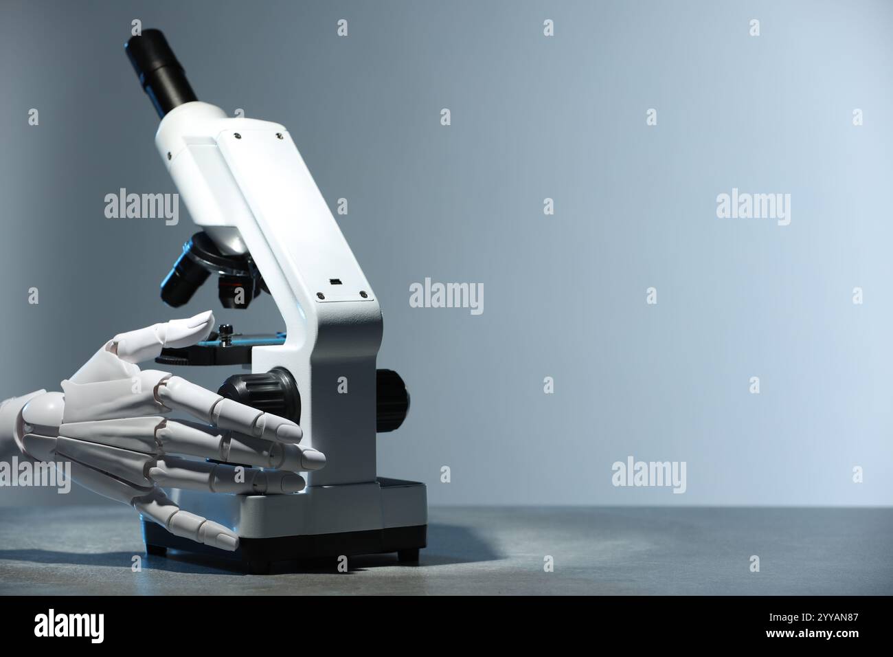 Artificial intelligence. Robot hand working with microscope at table ...