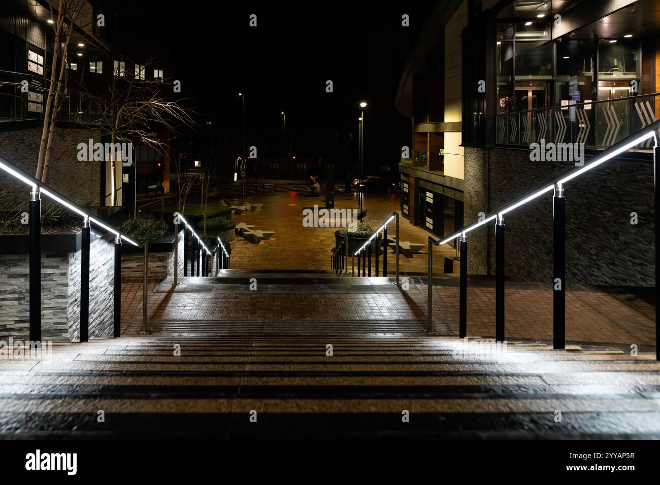 Modern architecture featuring illuminated handrails leading down steps ...