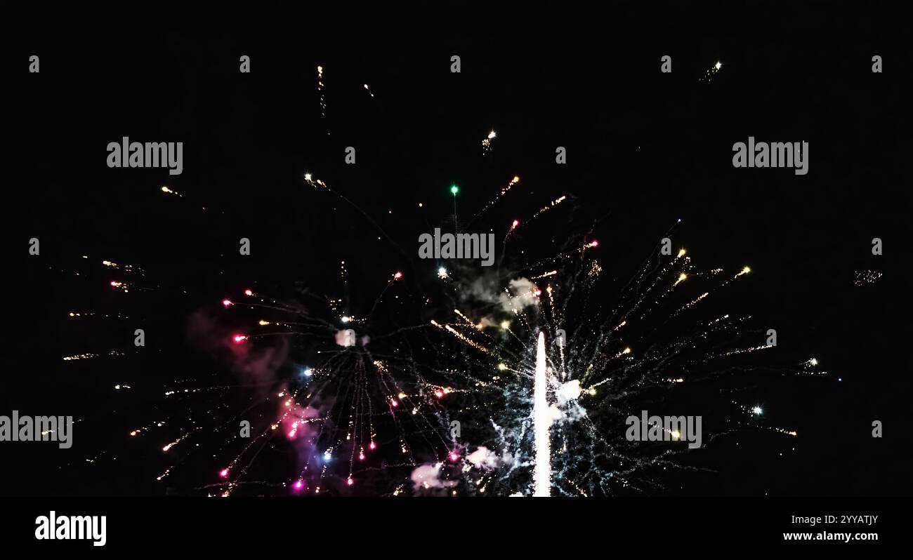 Vibrant fireworks burst into the night sky, creating a spectacular ...