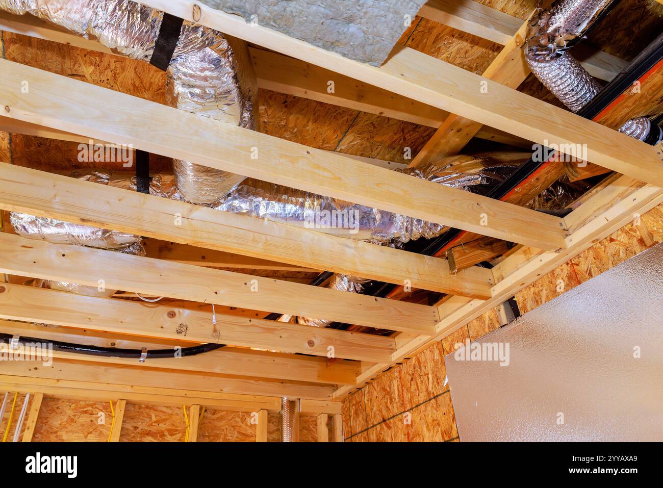 Exposed wooden framing in residential construction area with ductwork ...