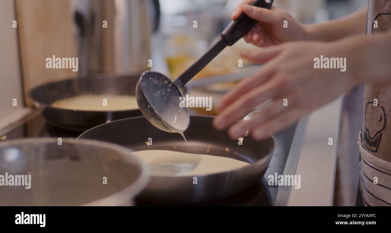 Pouring Pancake Batter into Pan While Frying Stock Photo - Alamy