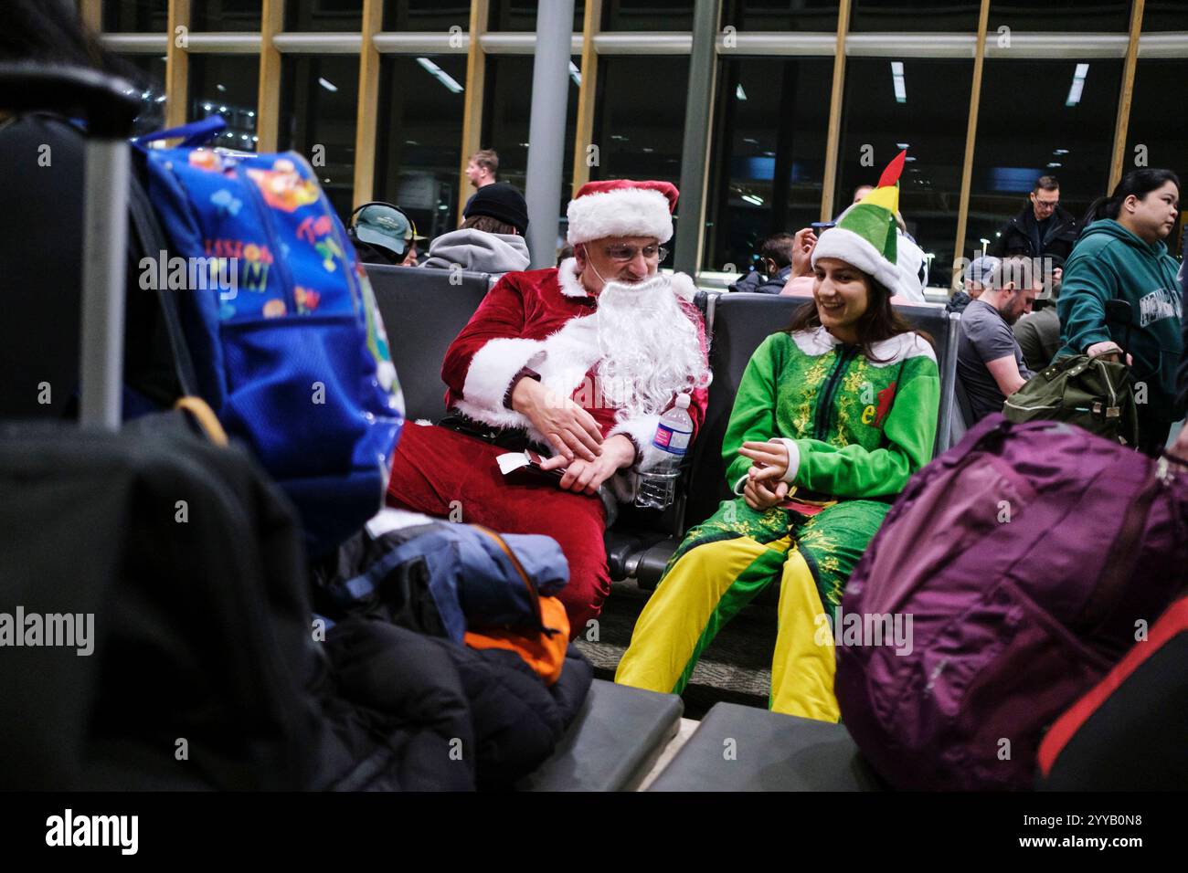 Dressed as Santa Claus and his elf, Victor Fernandez-Davila, of New ...