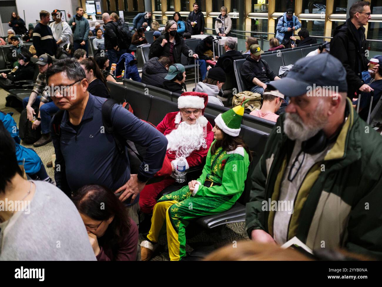 Dressed as Santa Claus and his elf, Victor Fernandez-Davila, of New ...