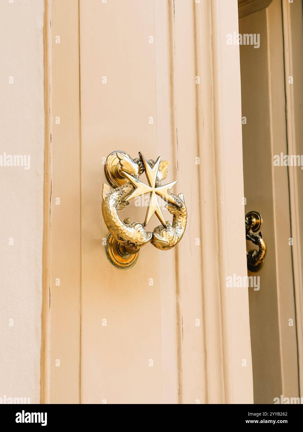 Traditional door handle with a Maltese cross and two fishes close-up ...
