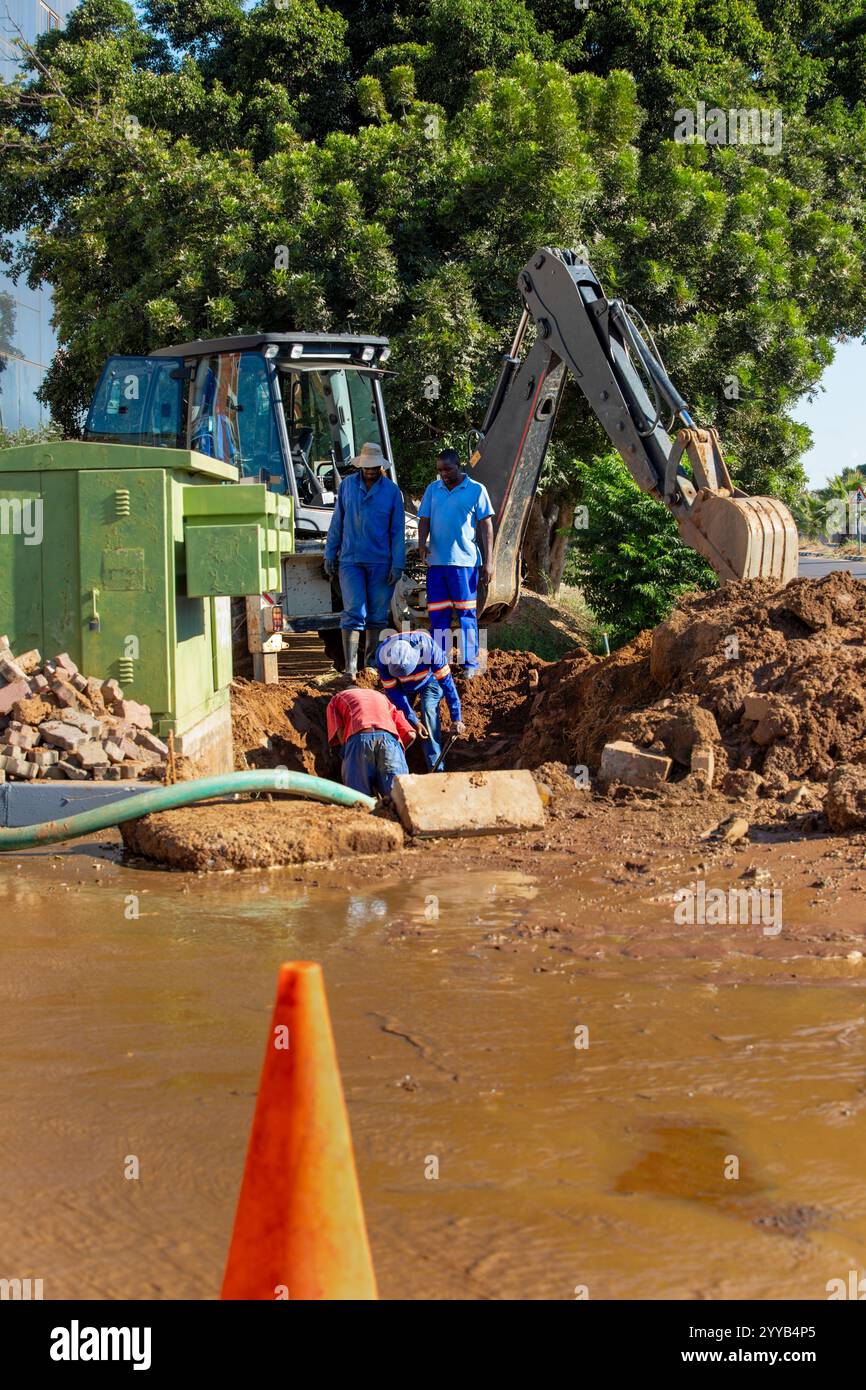 african american construction workers with an excavator fixing a ...