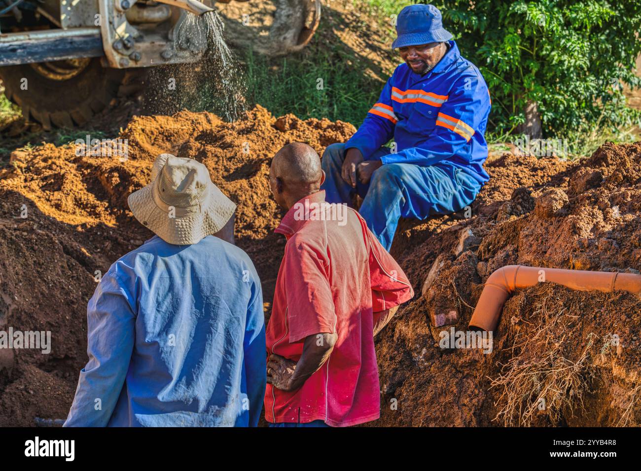african american plumber construction workers fixing a blocked drainage ...