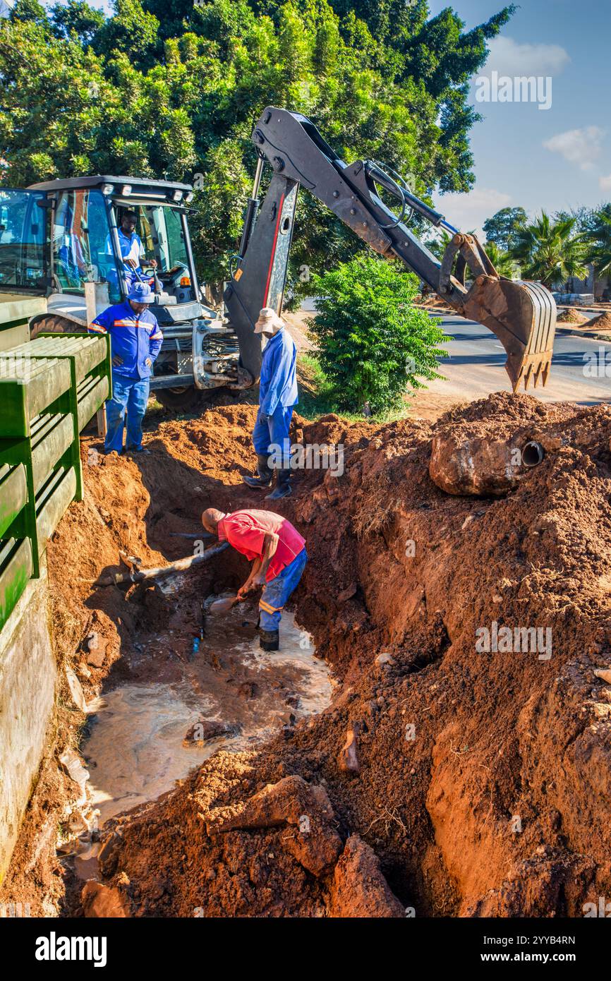 african american construction workers with an excavator fixing a ...